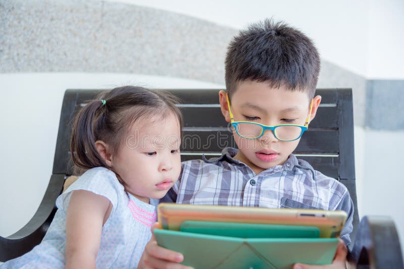 Boy and Girl Playing Games on Tablet Computer Stock Photo - Image of ...