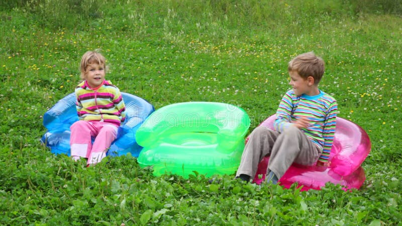 Boy and Girl Sitting on Inflatable Stock Footage - Video of armchair ...