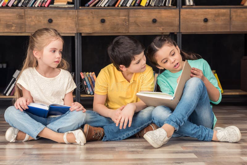 Boy and Girls Reading Books Stock Image - Image of shelves, classmates ...