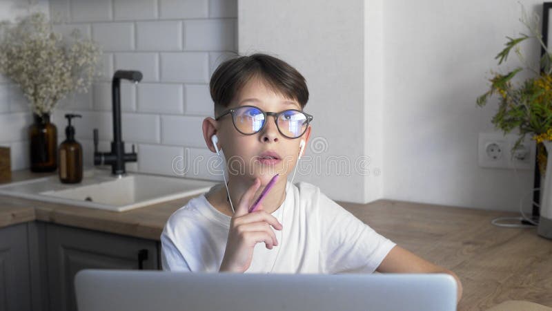A Boy with Glasses and Headphones in an Online Lesson. Distance ...