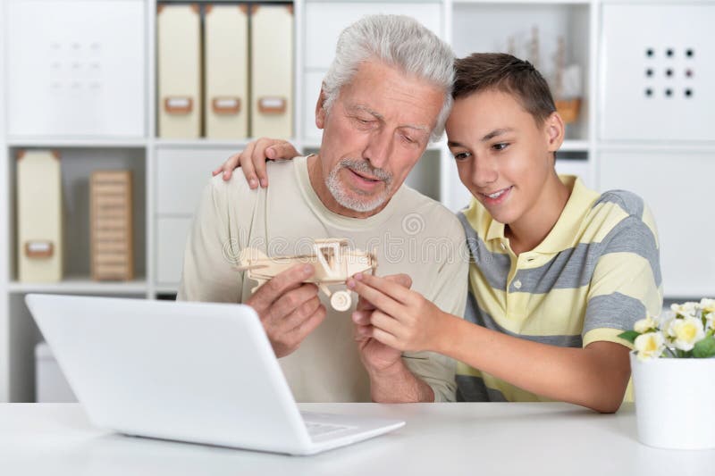 Boy and Grandfather with a Laptop at Home Making Plane Model Stock ...
