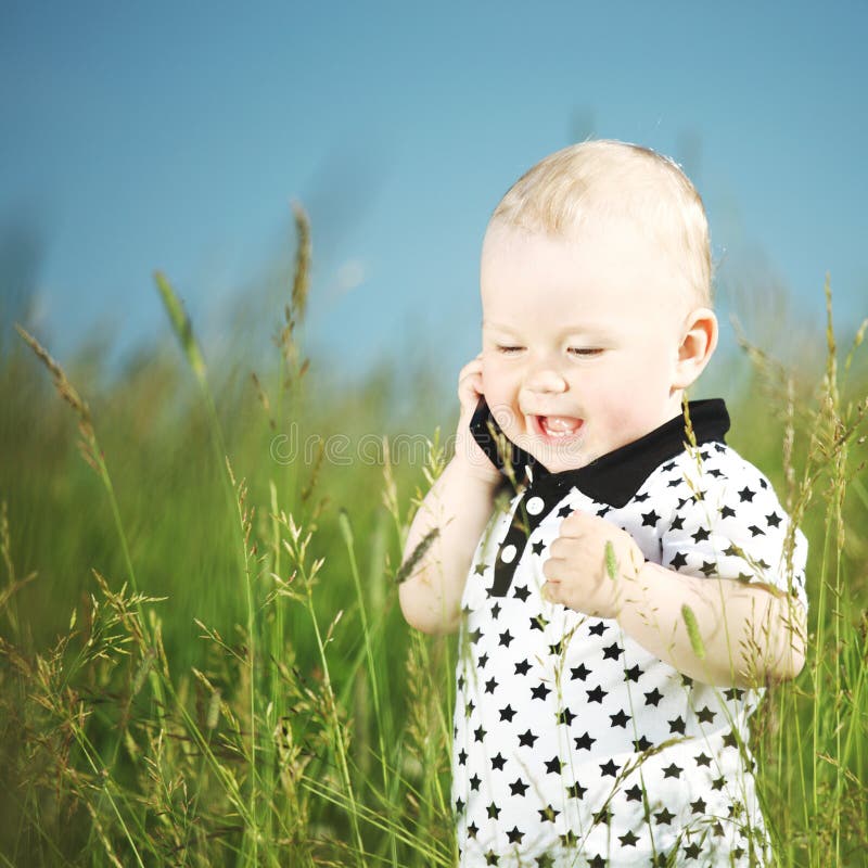 Boy in grass call by phone stock photo. Image of beautiful - 178018462