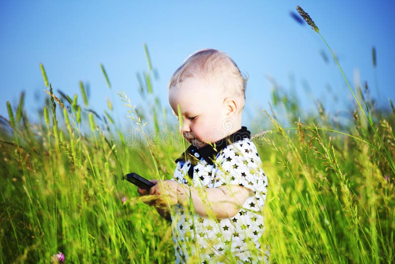 Boy in grass call by phone stock image. Image of beautiful - 32013427