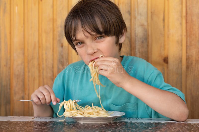 Boy Greedily Eats Spaghetti with Parmesan with His Hands Stock Image ...