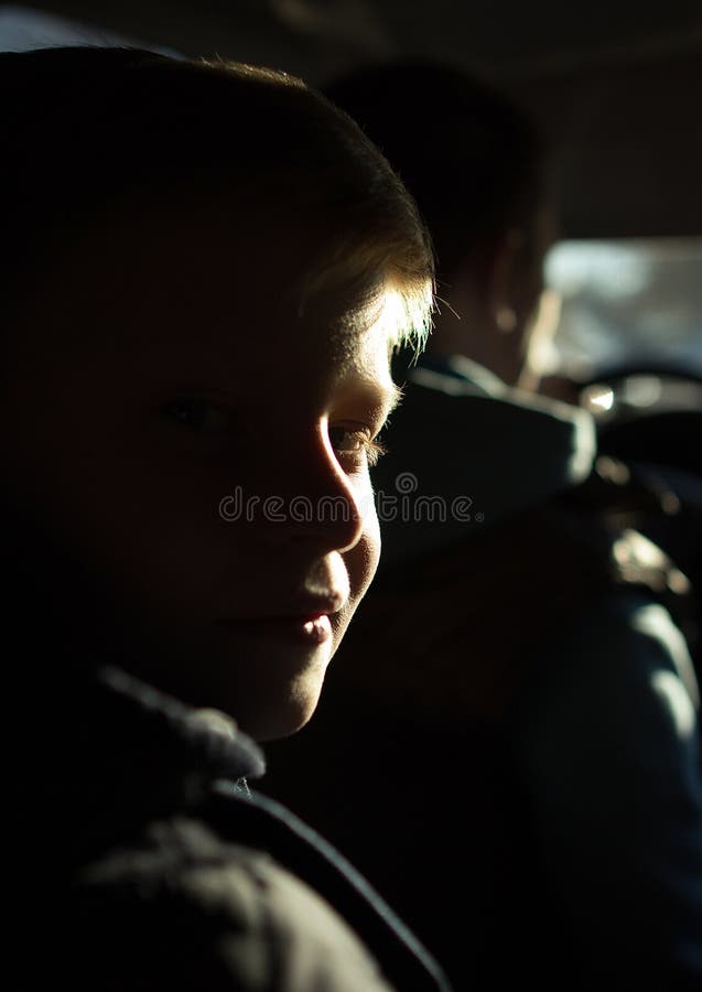 A Boy with Half-lighted Face Looking To the Camera. Boy`s Face in the ...