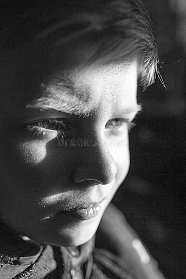 A Boy with Half-lighted Face Looking To the Camera. Boy`s Face in the ...