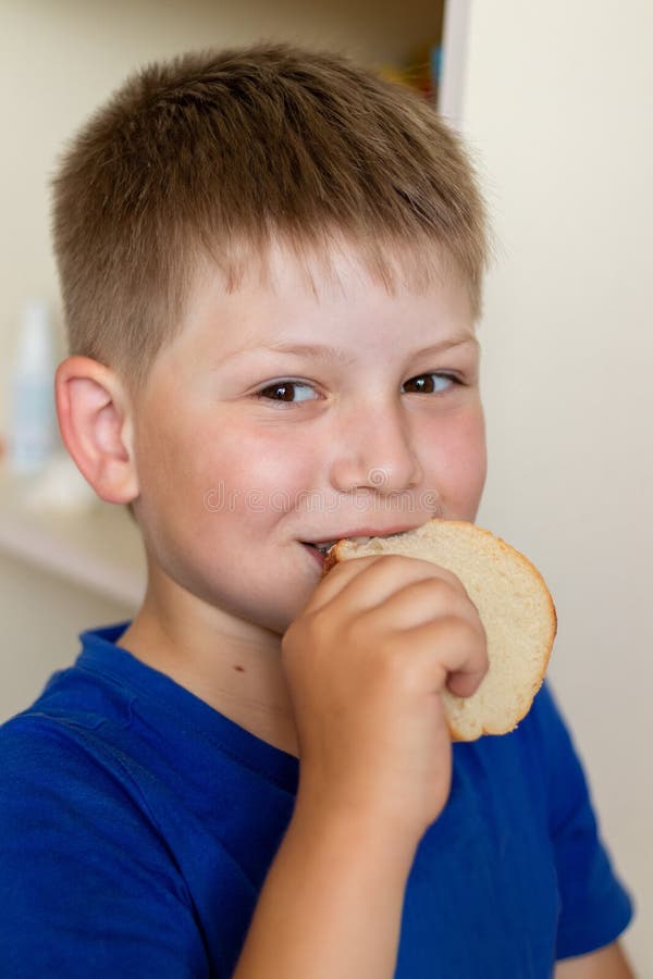 The Boy is Happy To Eat Bread, a Hungry Boy Stock Photo - Image of ...