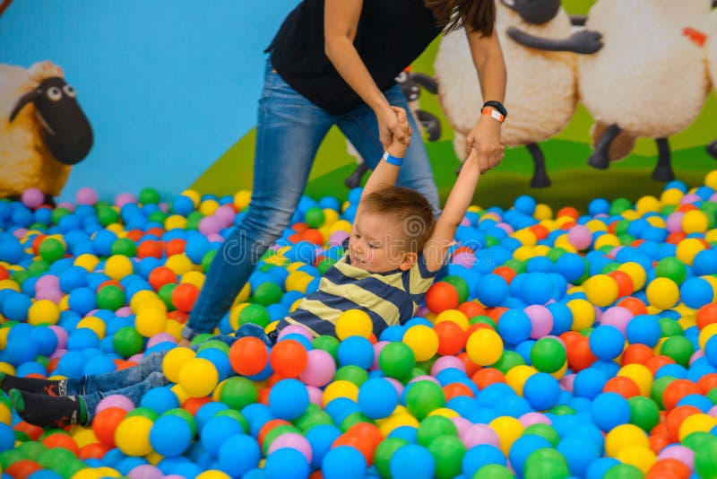 A Boy with Mother in the Playing Room with Many Little Colored Balls ...