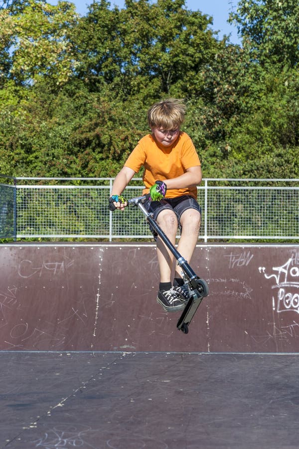Boy Has Fun Riding Push Scooter at the Skate Park Stock Photo - Image ...