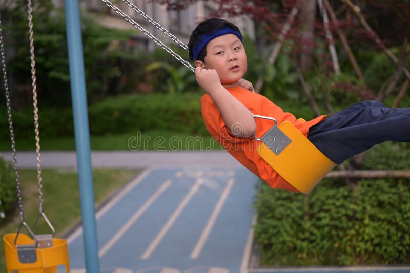 Boy have a ride on a swing stock photo. Image of playground - 279333082
