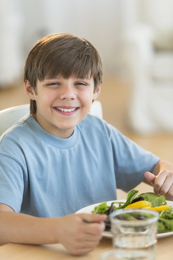 Boy Having Fresh Salad at Dining Table Stock Photo - Image of glass ...