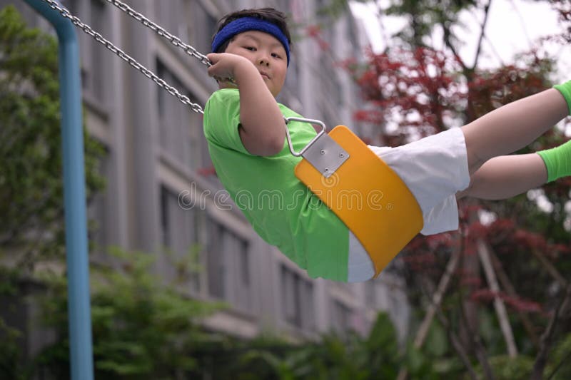 A Boy with a Headband Have a Ride on a Swing Stock Image - Image of ...