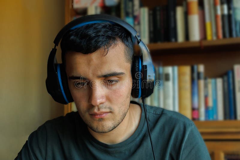 Boy with Headphones Studying and Doing Computer Video Conferencing in a ...