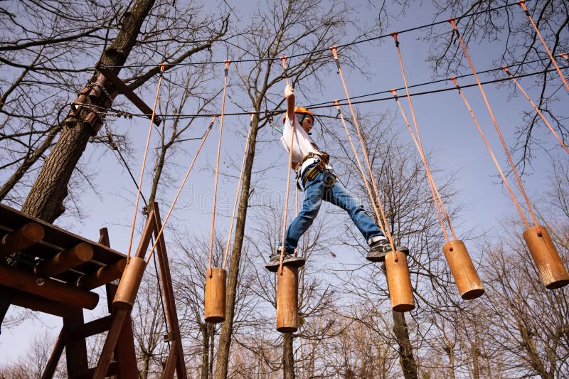 A Boy in a Helmet Climbs a Rope Park in Spring Stock Photo - Image of ...