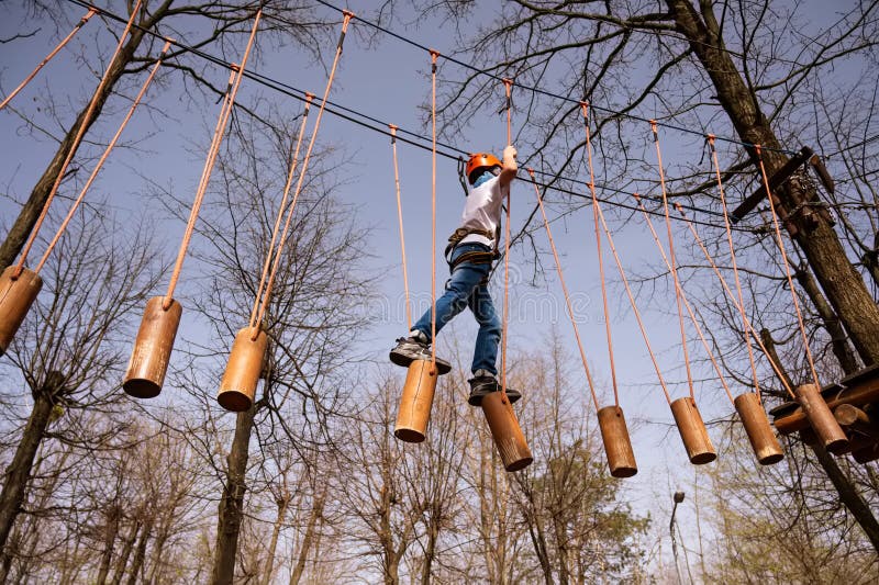 A Boy in a Helmet Climbs a Rope Park in Spring Stock Image - Image of ...