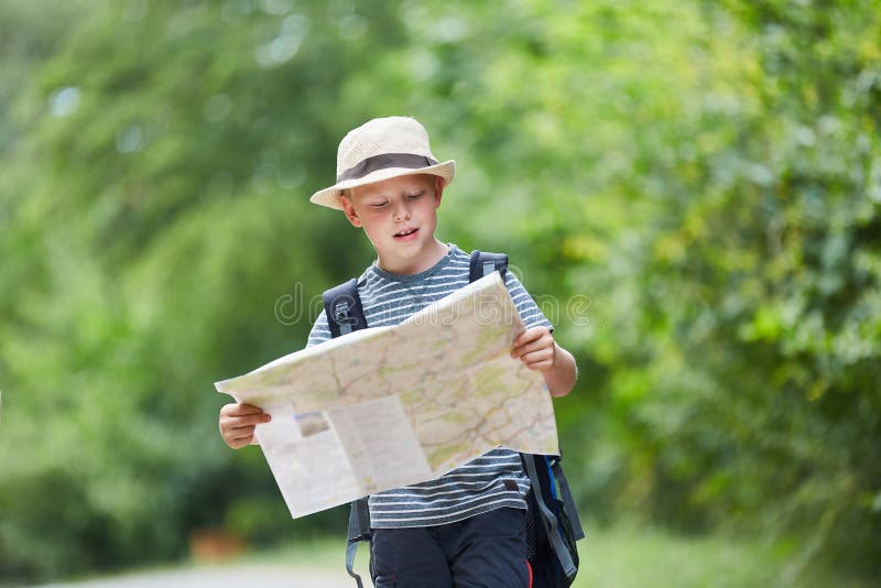Boy on a hike looks on map stock image. Image of kids - 169959111
