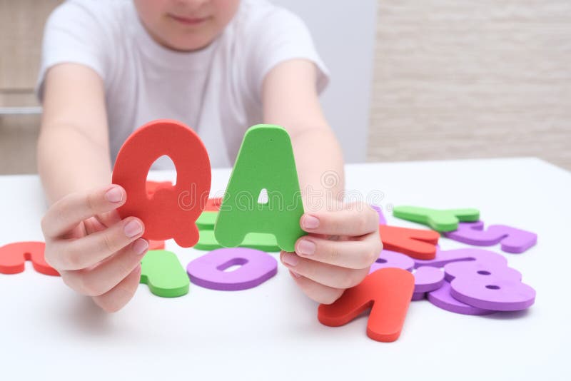 A Boy Holding Colorful Letters Q and a, Questions and Answers Concept ... A Boy Holding Colorful Letters Q and a, Questions and Answers Concept ...