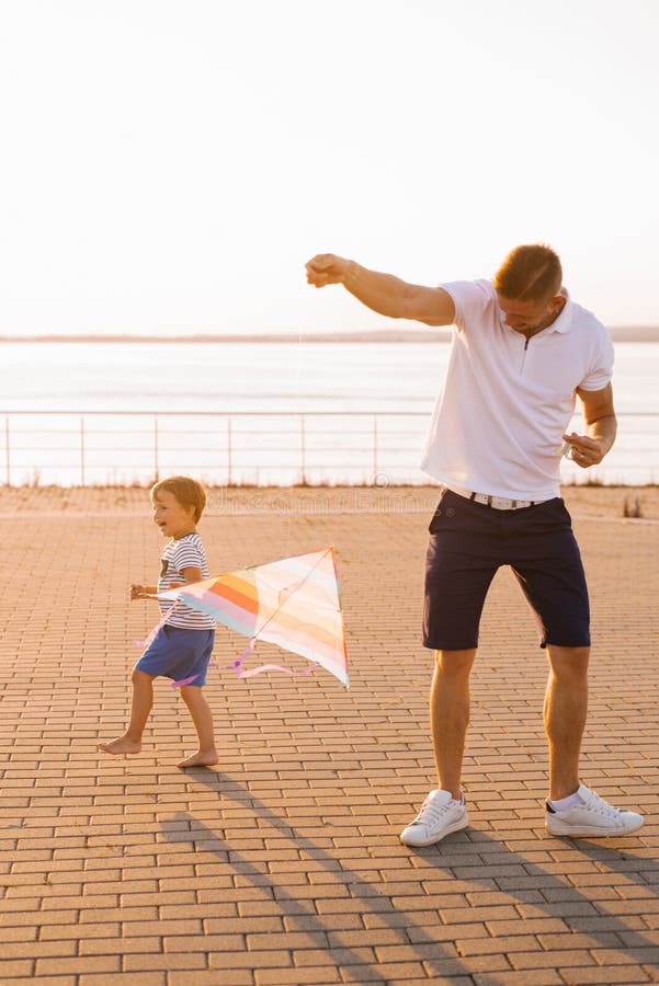 Boy Holding Kite String while Father Guides it Stock Image - Image of ...