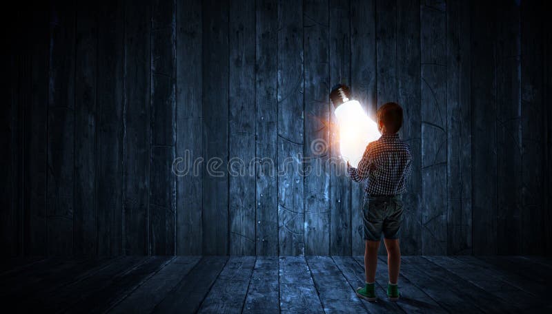 Boy holding a light bulb stock photo. Image of discovery - 204762468