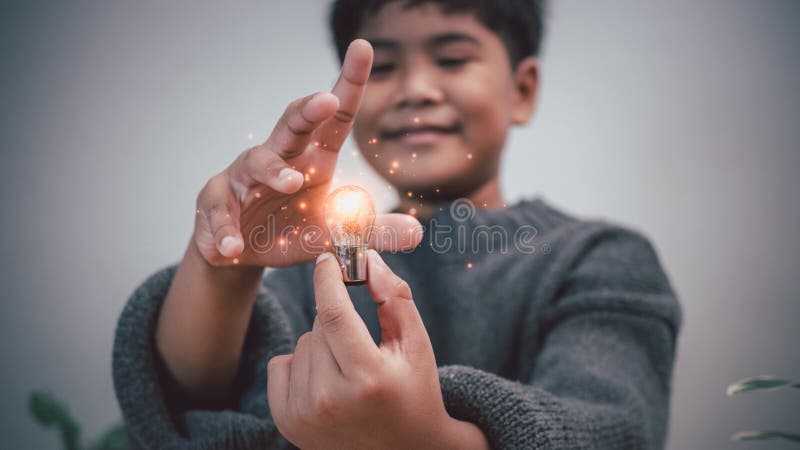 The Boy is Holding a Light Bulb. it Represents the Concept of Education ...