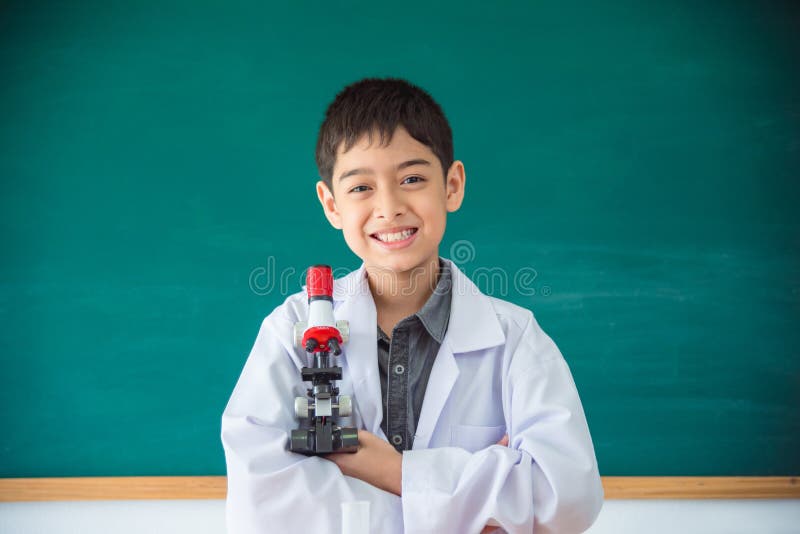 Boy Holding Microscope Smiling in Front of Classroom Stock Image ...