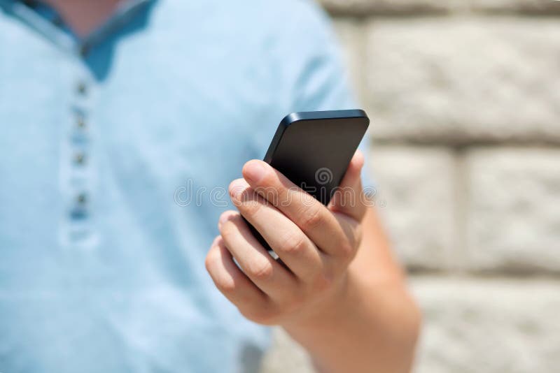 Boy Holding a Phone Against a Green Wall Stock Photo - Image of media ...
