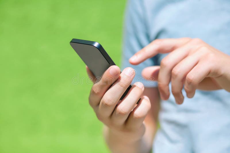 Boy Holding a Phone and a Touch Screen for Finger Against a Green Wall ...