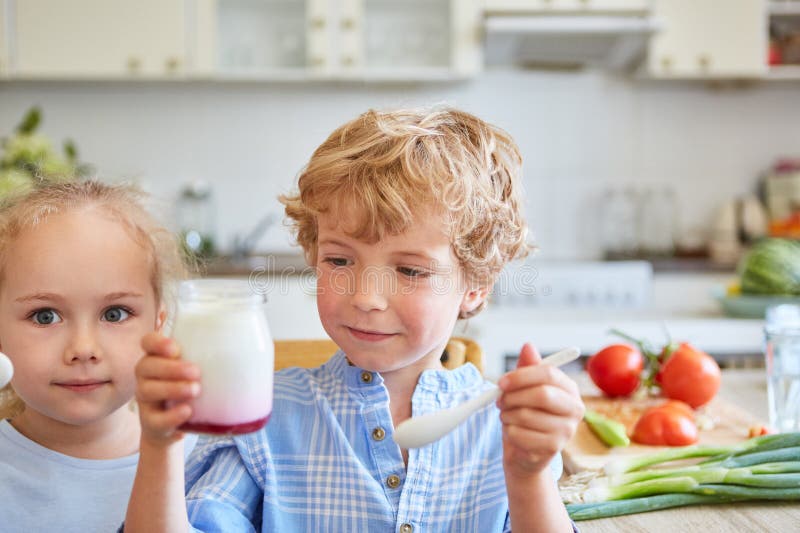 Boy Holding Spoon and Parfait Jar with Sister at Home Stock Photo ...