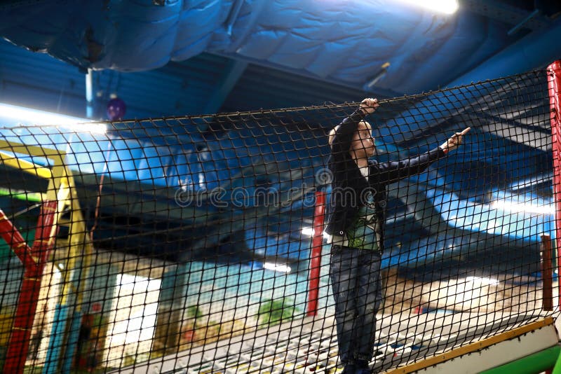 Boy holding on to rope net stock image. Image of leisure - 162847301