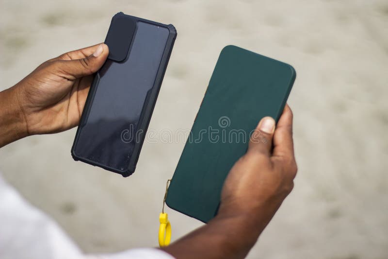 A Boy is Holding Two Mobile Phones and the Screen is Black and Blue ...