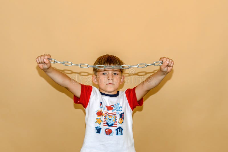 The Boy Holds a Chain in His Hands in Front of His Face Stock Photo ...