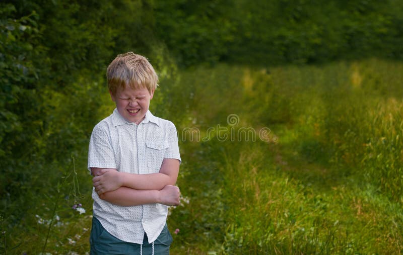 Boy Holds His Hand and Winces at the Pain in the Park Stock Photo ...