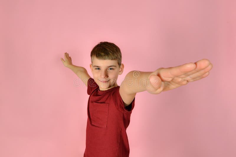 The Boy Holds His Hands To the Sides, One Arm Extended Forward, the ...