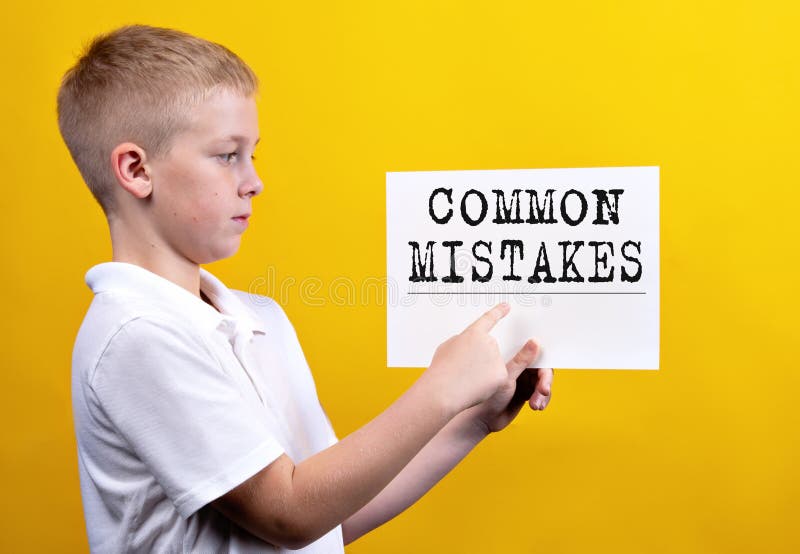 A Boy Holds a White Sheet with the Inscription COMMON MISTAKES on a ...