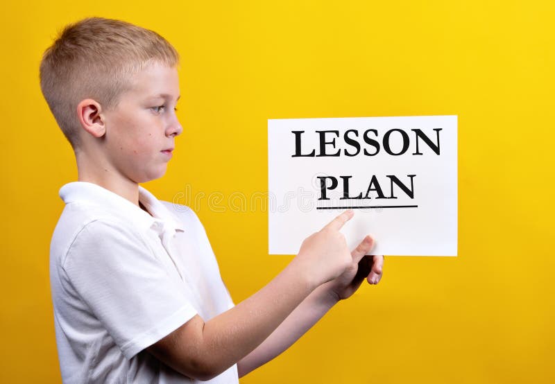 A Boy Holds a White Sheet with the Inscription LESSON PLAN on a Yellow ...