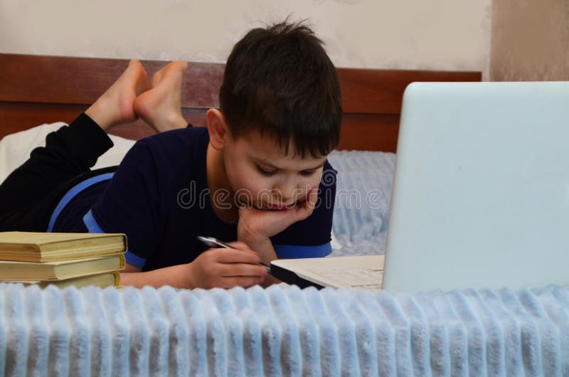 Boy at Home on the Couch or Bed Doing Housework, Studying the Subject ...