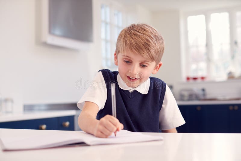 Boy at Home Wearing School Uniform Doing Homework on Kitchen Counter ...