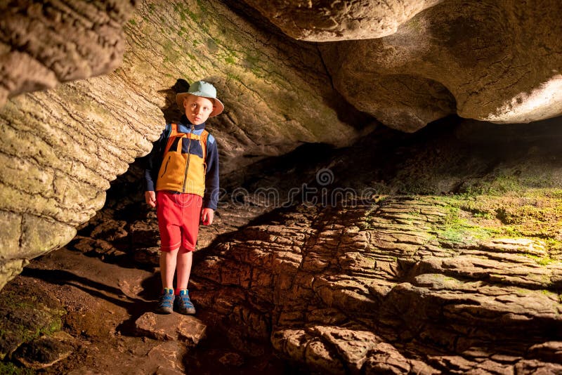 Boy Inside the Ancient Cave with Stone Walls with Additional Lighting ...
