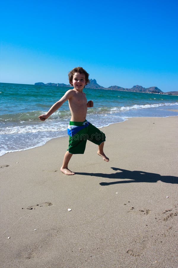 Boy Jumping Around on the Beach Stock Photo - Image of shadow, clear ...
