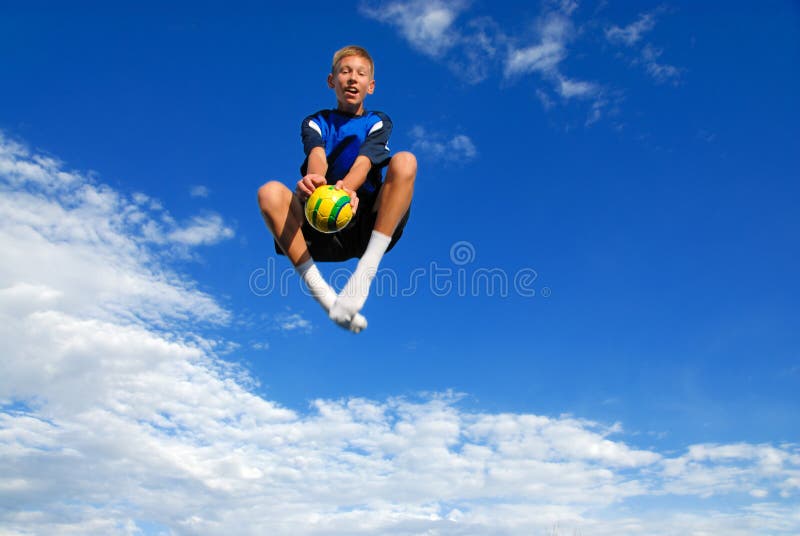 Boy jumping high with ball stock photo. Image of smile - 3542100