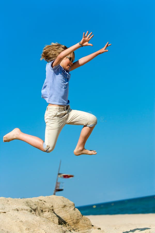 Boy jumping high on beach. stock image. Image of little - 31229107