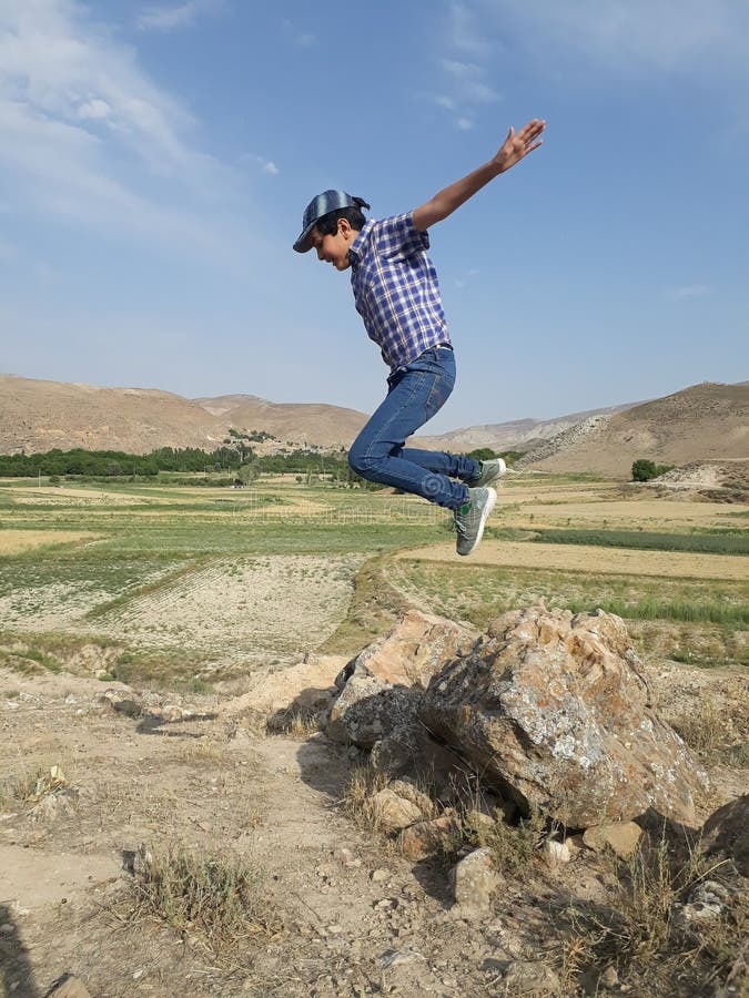 Boy jumping in landscape stock image. Image of active - 351494281