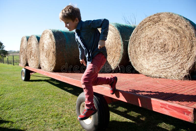 Boy Jumping Off Tractor Trailer Stock Image - Image of rural, outdoors ...
