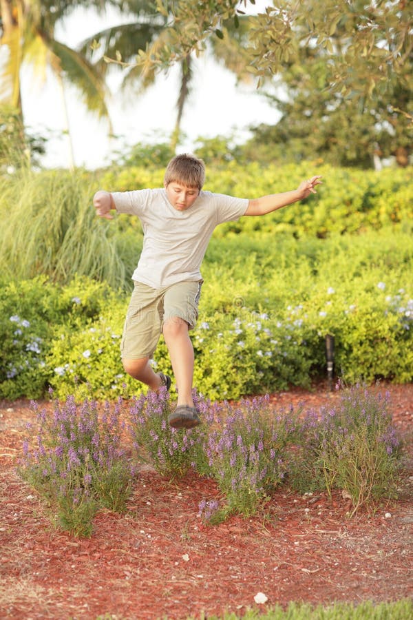 Boy jumping over a bush stock image. Image of action - 16760955