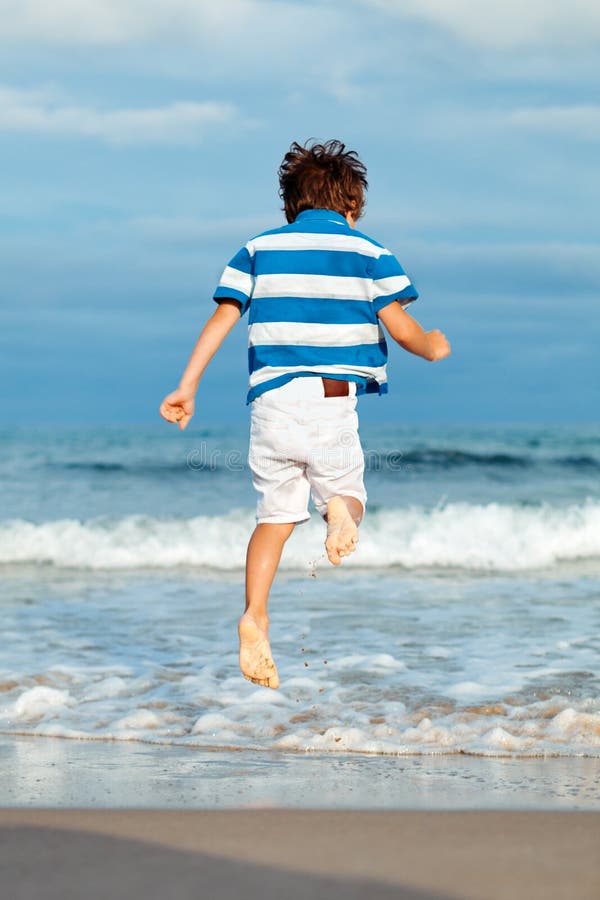 Boy jumping over waves stock image. Image of adult, beach - 32971603