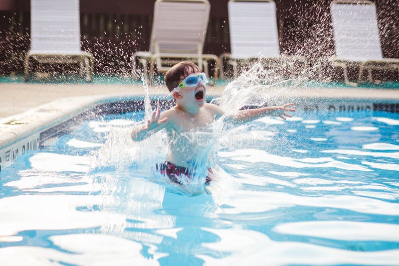 Boy jumping in to the pool stock photo. Image of joyful - 165688938