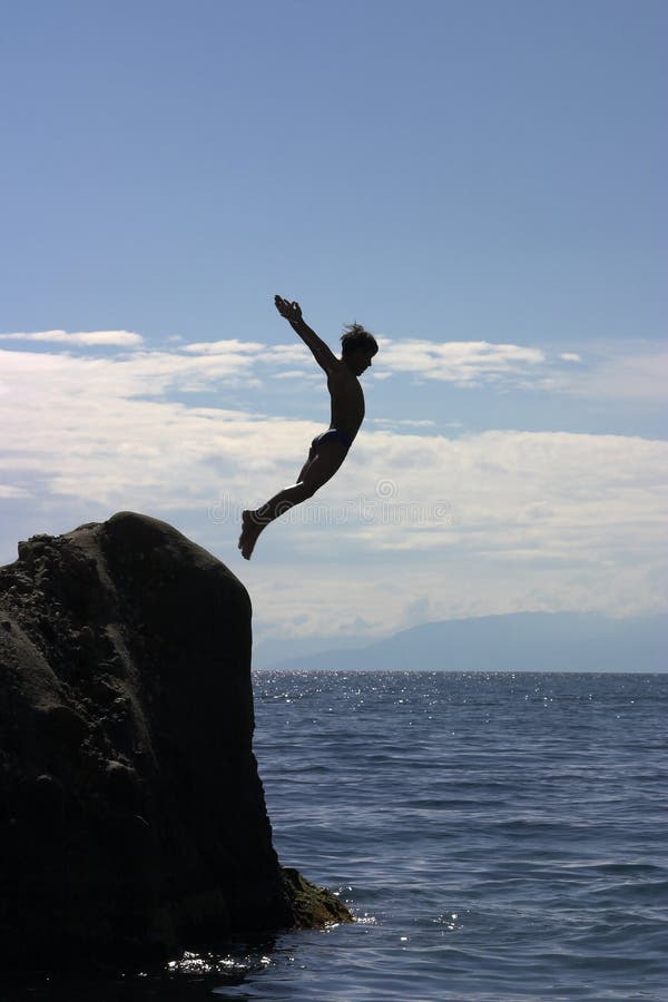 Boy jumping to the sea stock photo. Image of rock, resort - 7472728