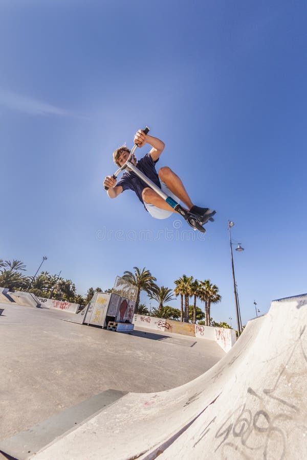 Boy Jumps with His Scooter Over a Ramp Stock Photo - Image of pipe ...