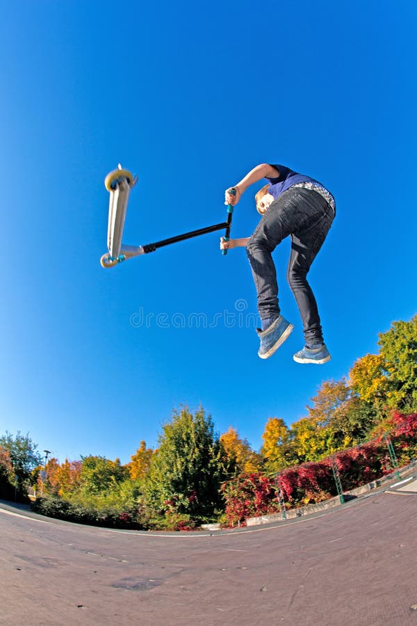Young Boy Jumps with Scooter Over a Ramp at the Sk Stock Image - Image ...