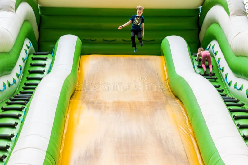 The Boy Jumps from an Inflatable Slide Stock Image - Image of emotion ...